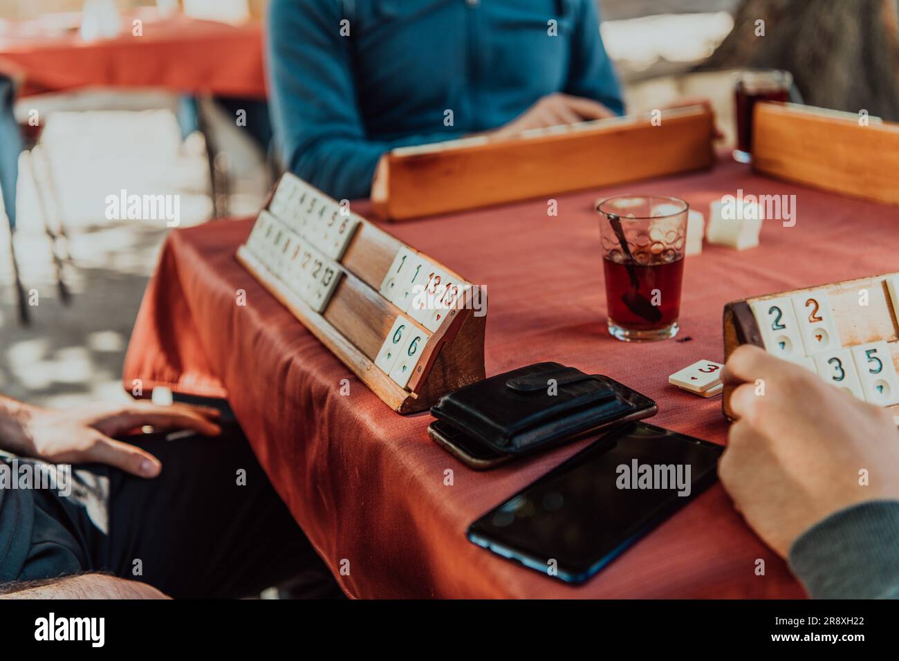 A group of men drink traditional Turkish tea and play a Turkish game ...