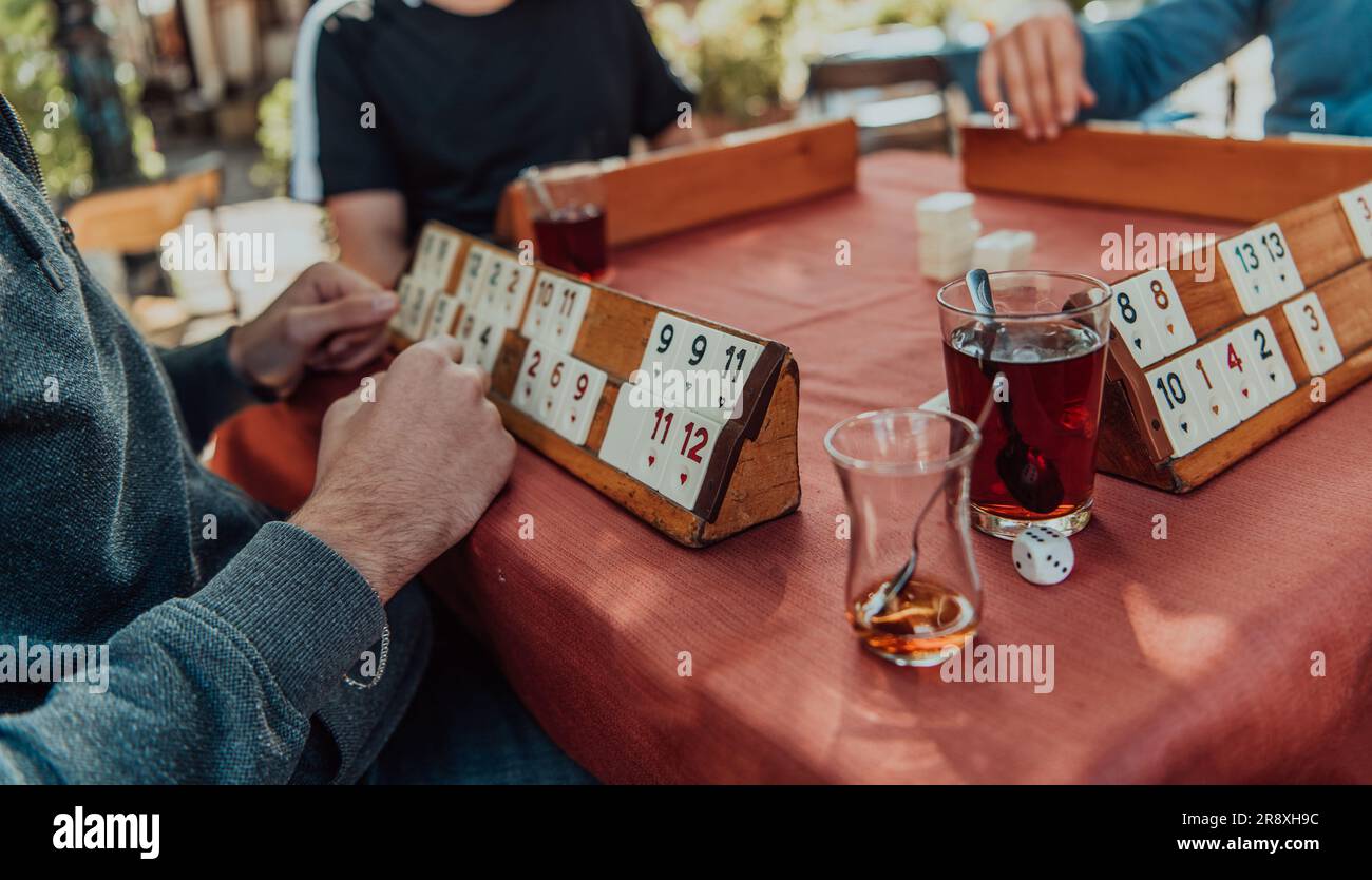 A group of men drink traditional Turkish tea and play a Turkish game ...