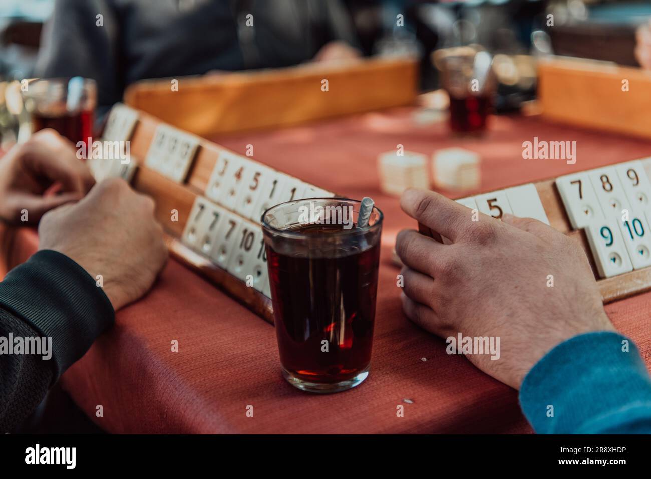 A group of men drink traditional Turkish tea and play a Turkish game ...