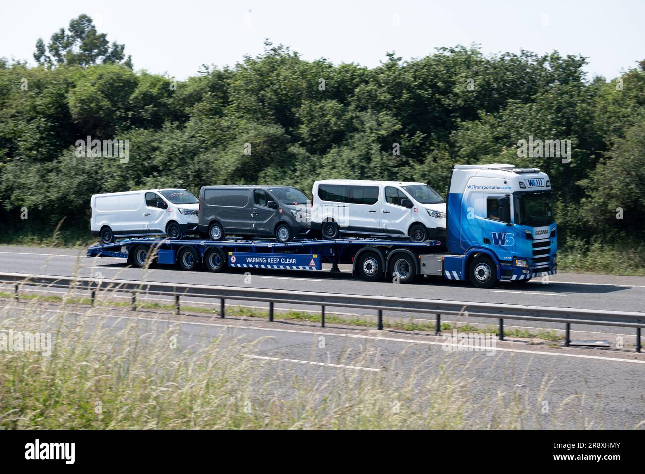 A WS Transportation low-loader carrying new vans on the M40 motorway ...