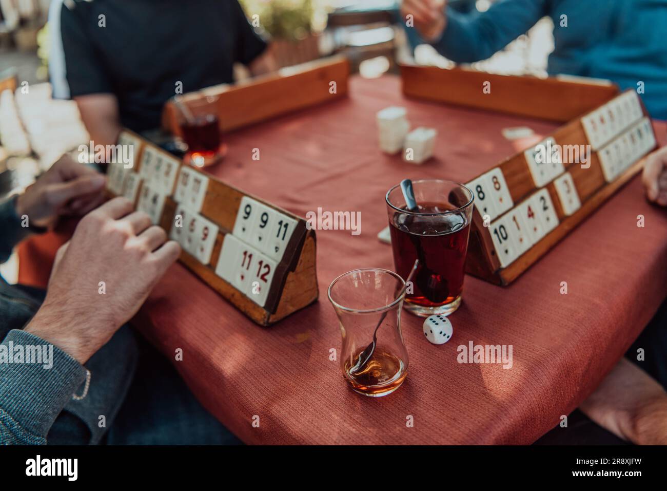 A group of men drink traditional Turkish tea and play a Turkish game ...