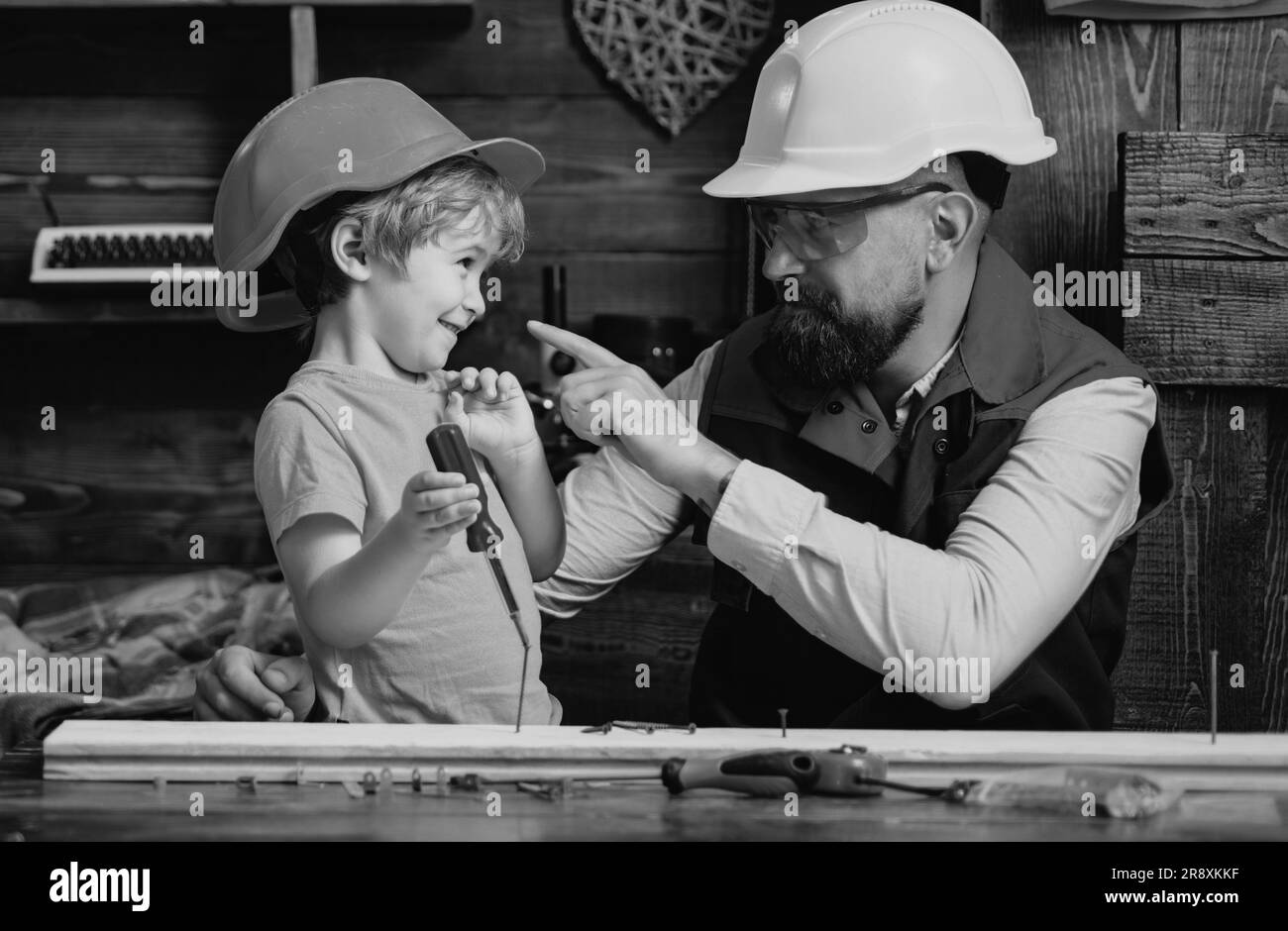 Tools construction. Father teaching little son to use carpenter tools ...