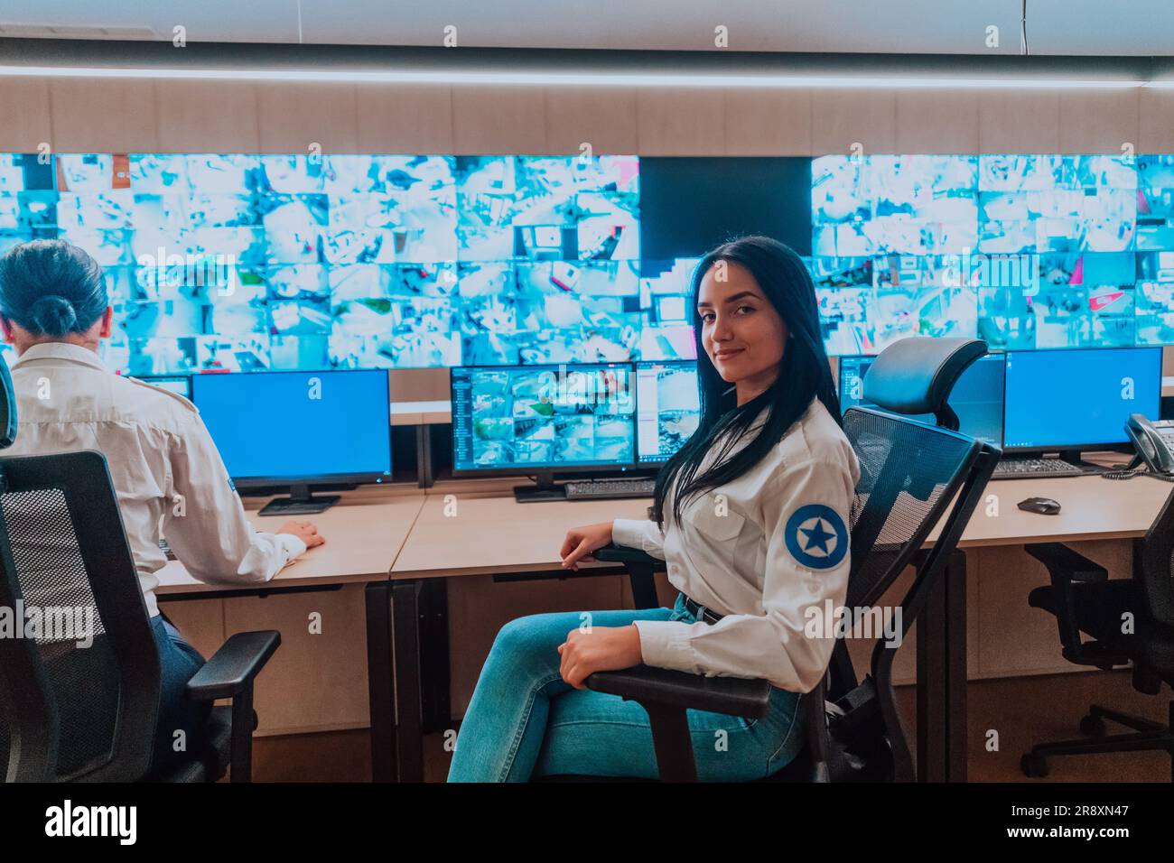 Female security operator working in a data system control room offices ...