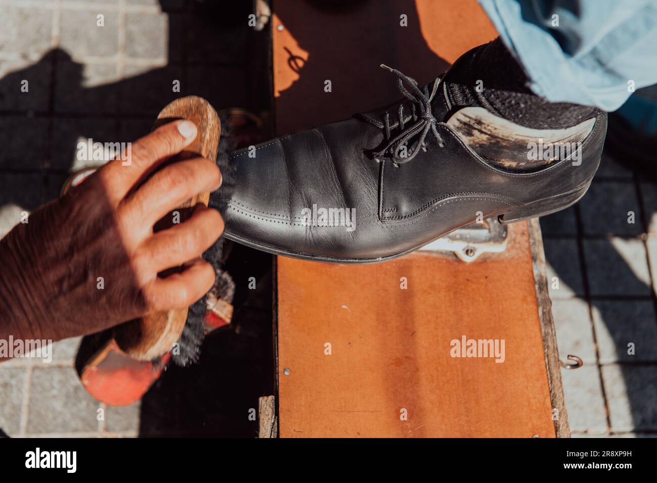 An old man hand polishing and painting a black shoe at street Stock ...