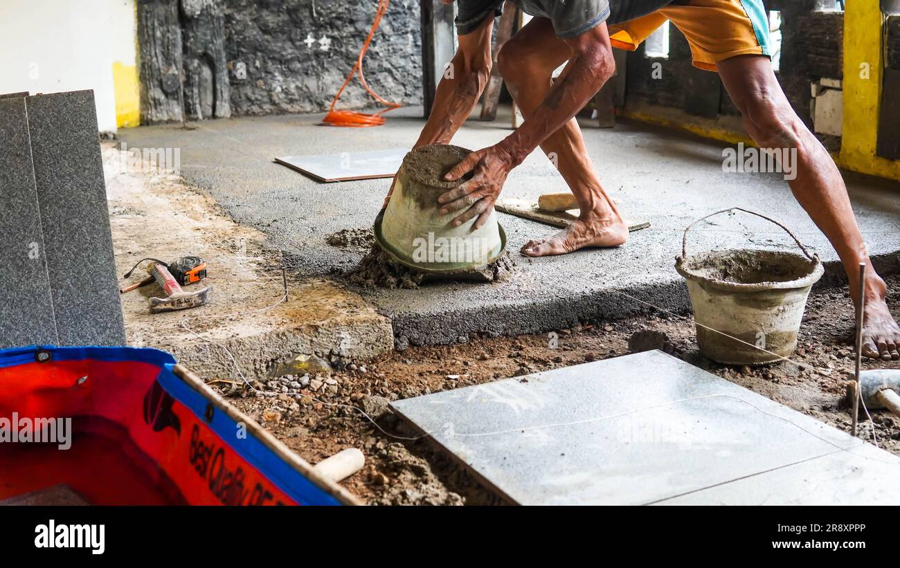 A male construction worker installs a large ceramic tile Stock Photo ...
