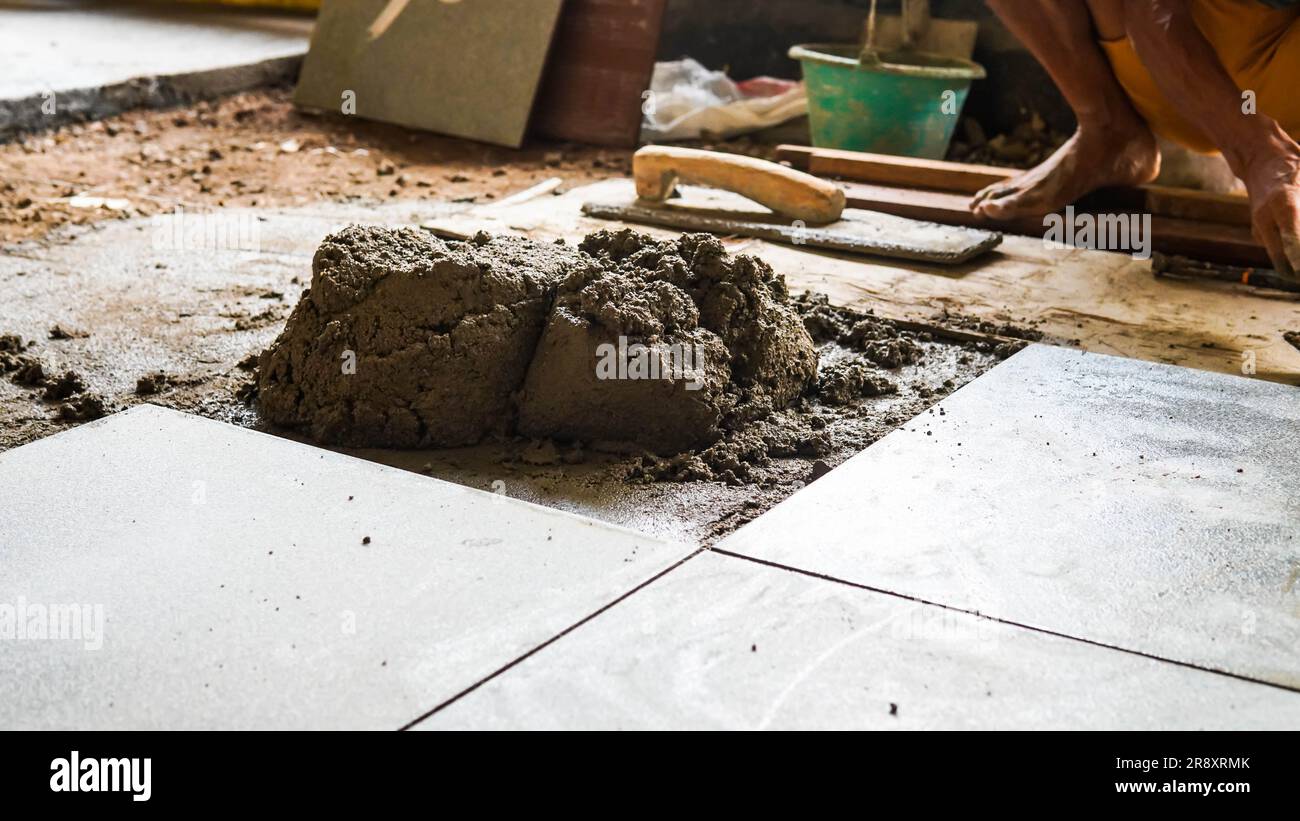 A male construction worker installs a large ceramic tile Stock Photo ...