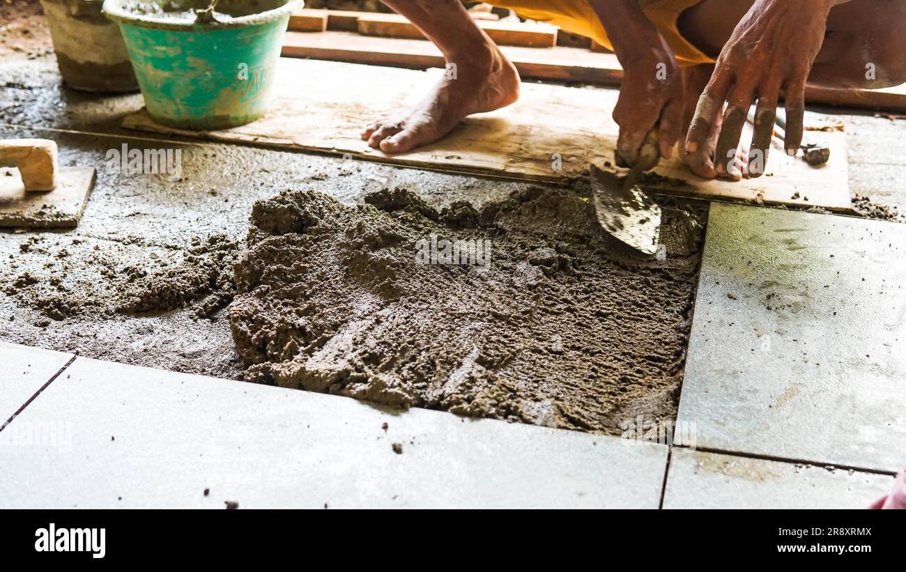 A male construction worker installs a large ceramic tile Stock Photo ...