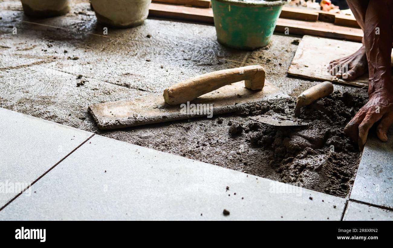 A male construction worker installs a large ceramic tile Stock Photo ...