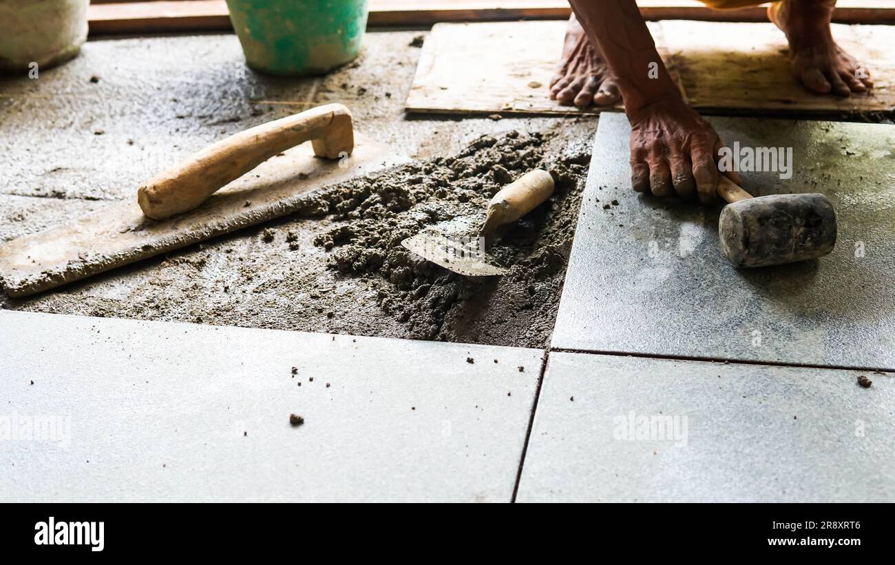 A male construction worker installs a large ceramic tile Stock Photo ...