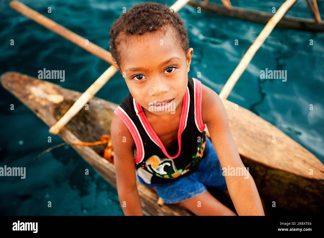 Children on an outrigger canoe at Nimoa Island in the Louisiades ...