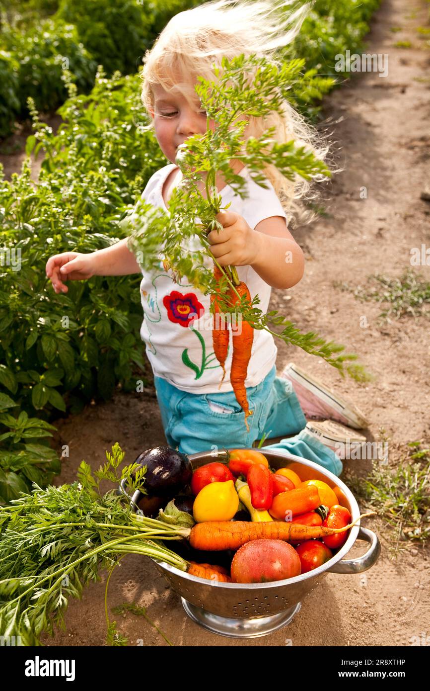 A young girl shows off organic produce at her family's farm Stock Photo ...