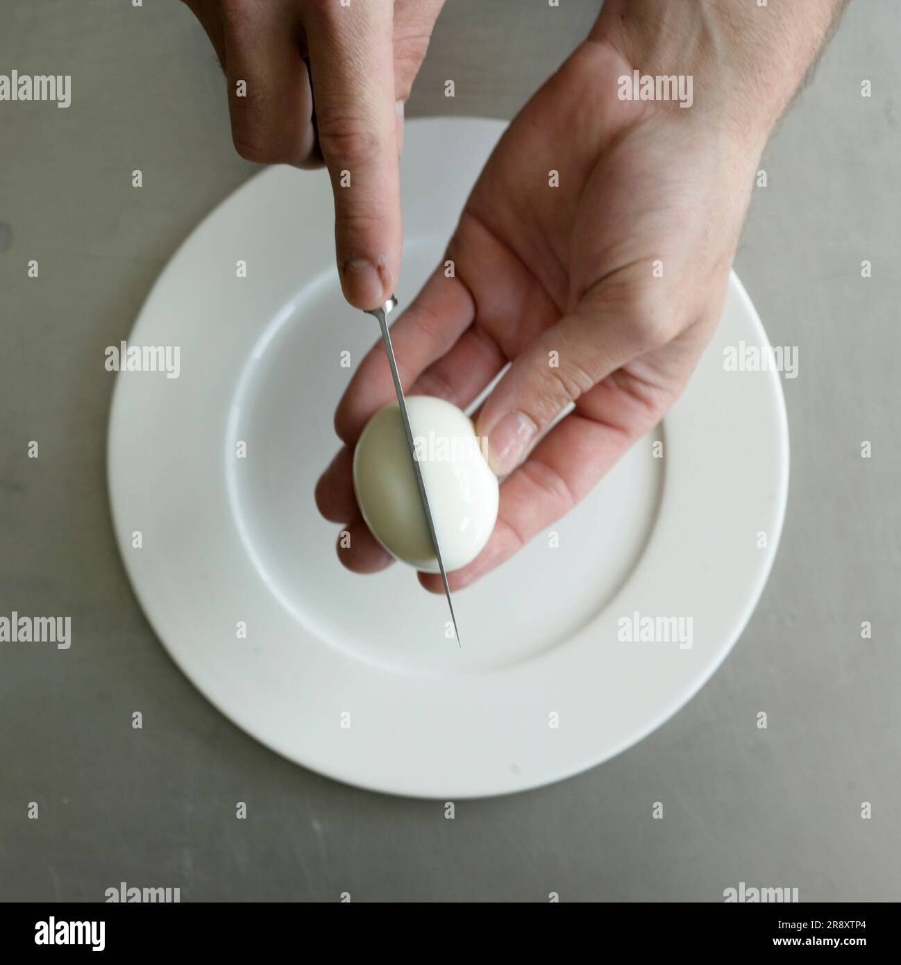 Hard Boiled Egg being split with a knife Stock Photo - Alamy