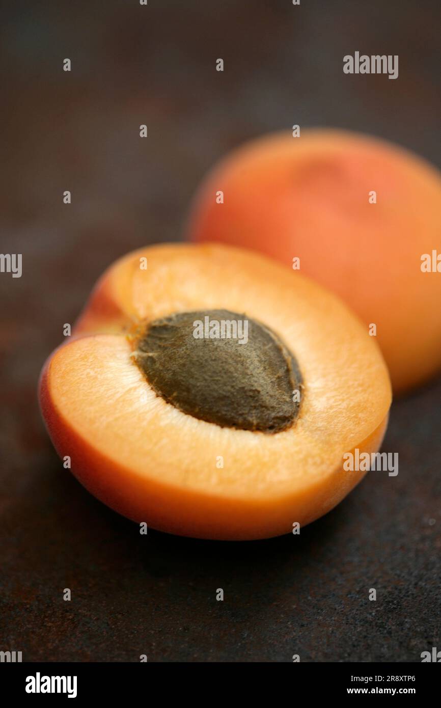 Apricot split open to reveal it's pit Stock Photo - Alamy