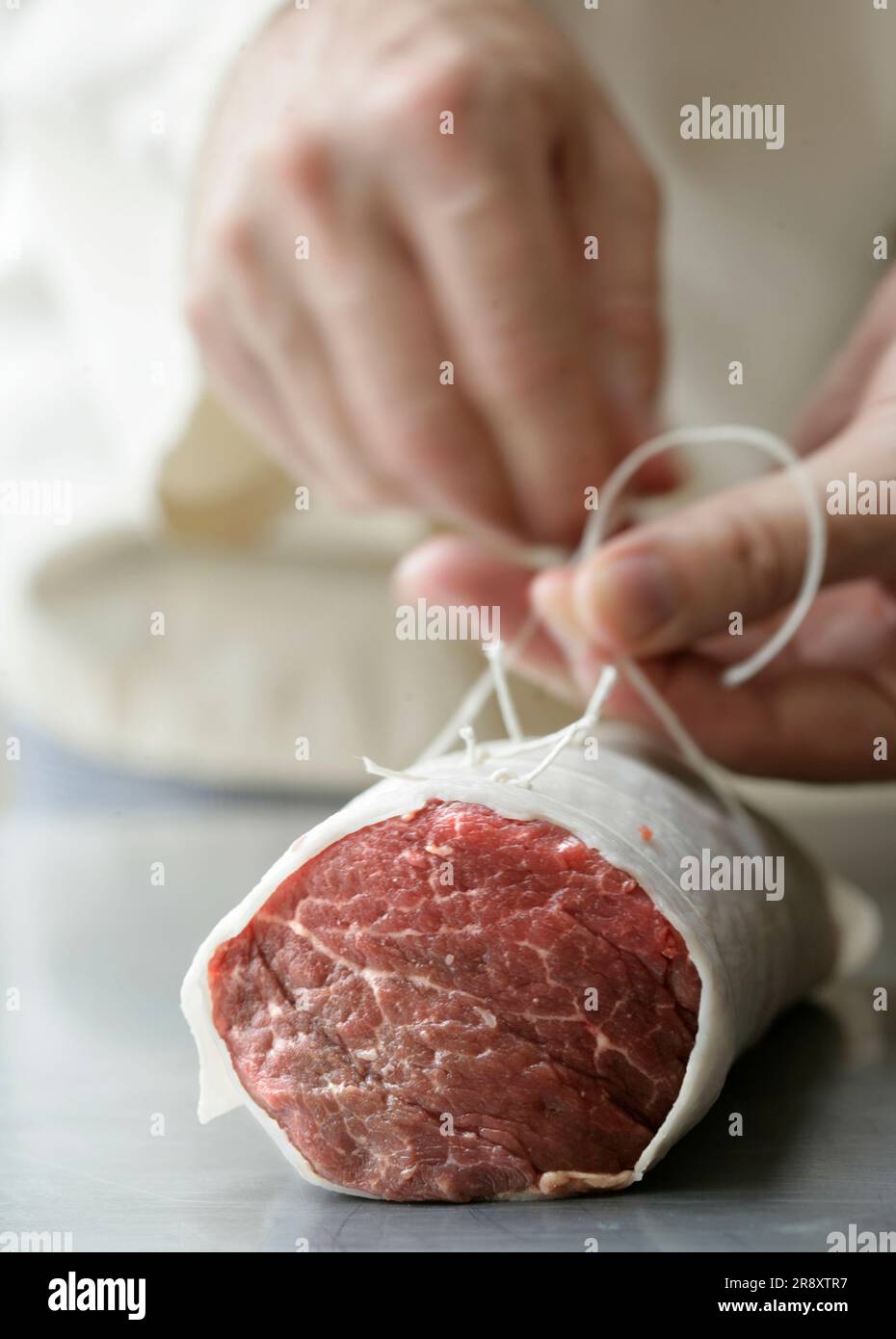 Ground beef being rolled and tied in paper Stock Photo - Alamy