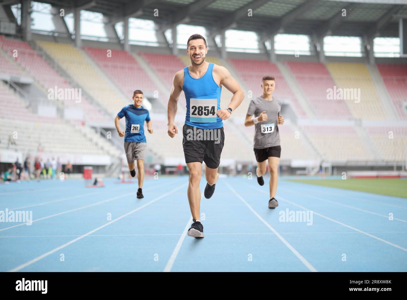 Full length portrait of men running a race at a stadium Stock Photo - Alamy