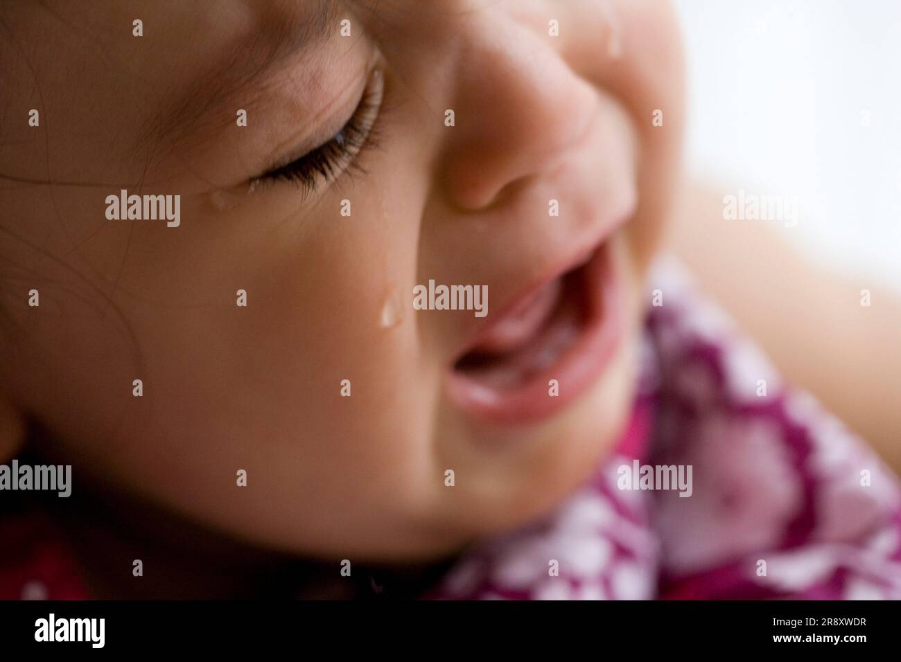 Close up of the face of a crying baby girl with tears streaming down her cheeks Stock Photo - Alamy