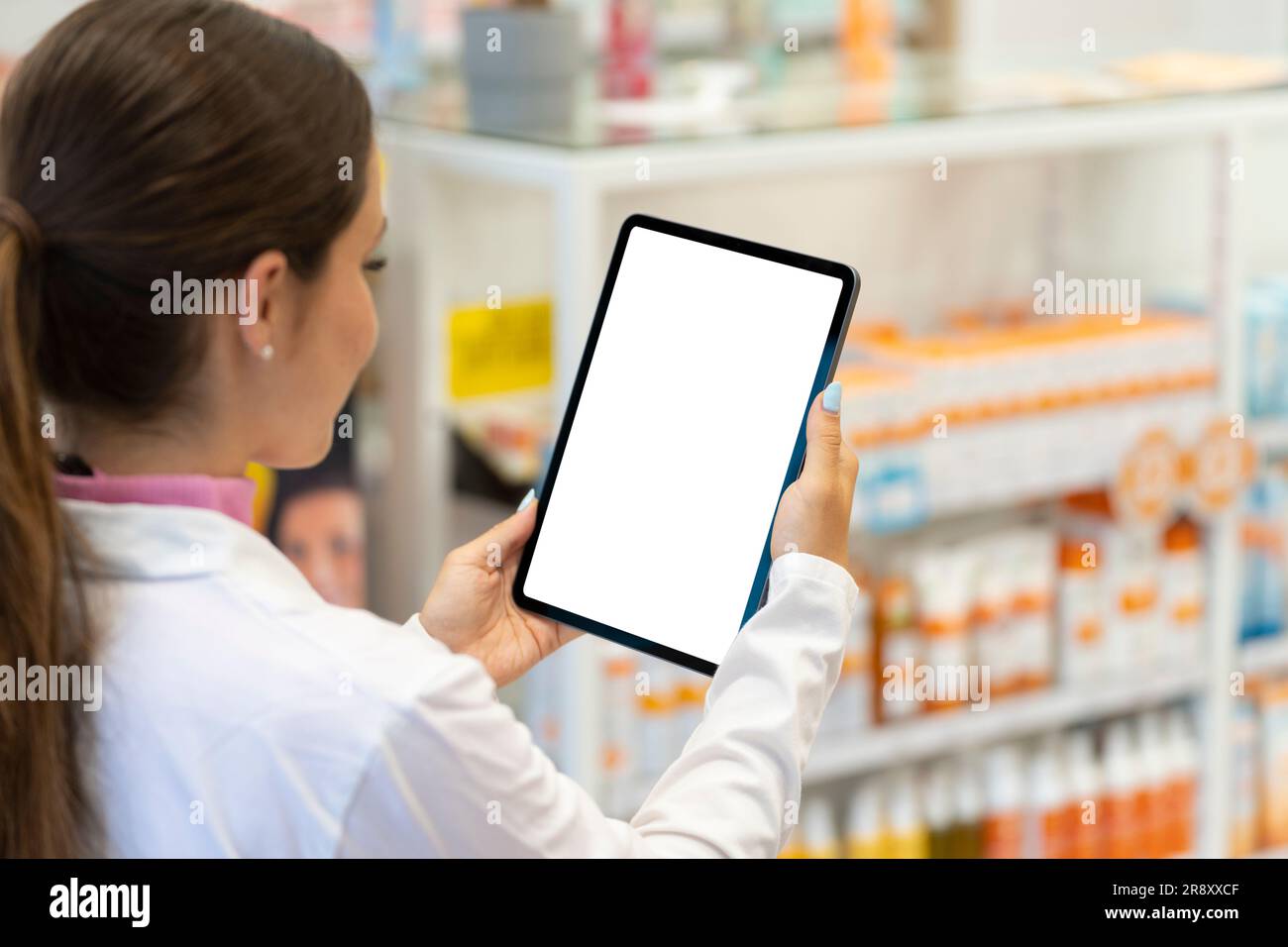 Female pharmacist looking at the screen of a digital tablet in the ...