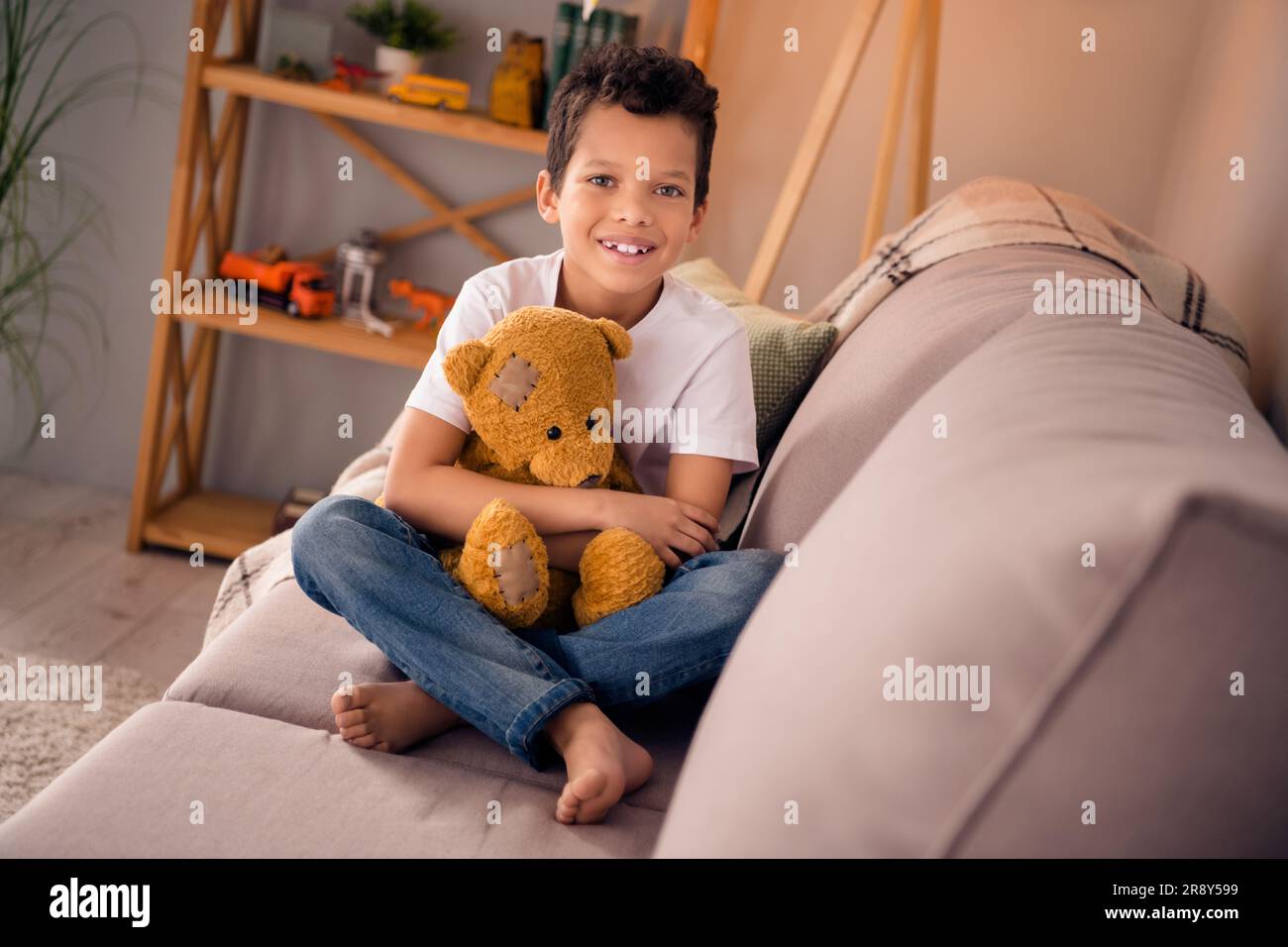 Photo of adorable sweet little boy sit comfy divan hug soft teddy bear ...