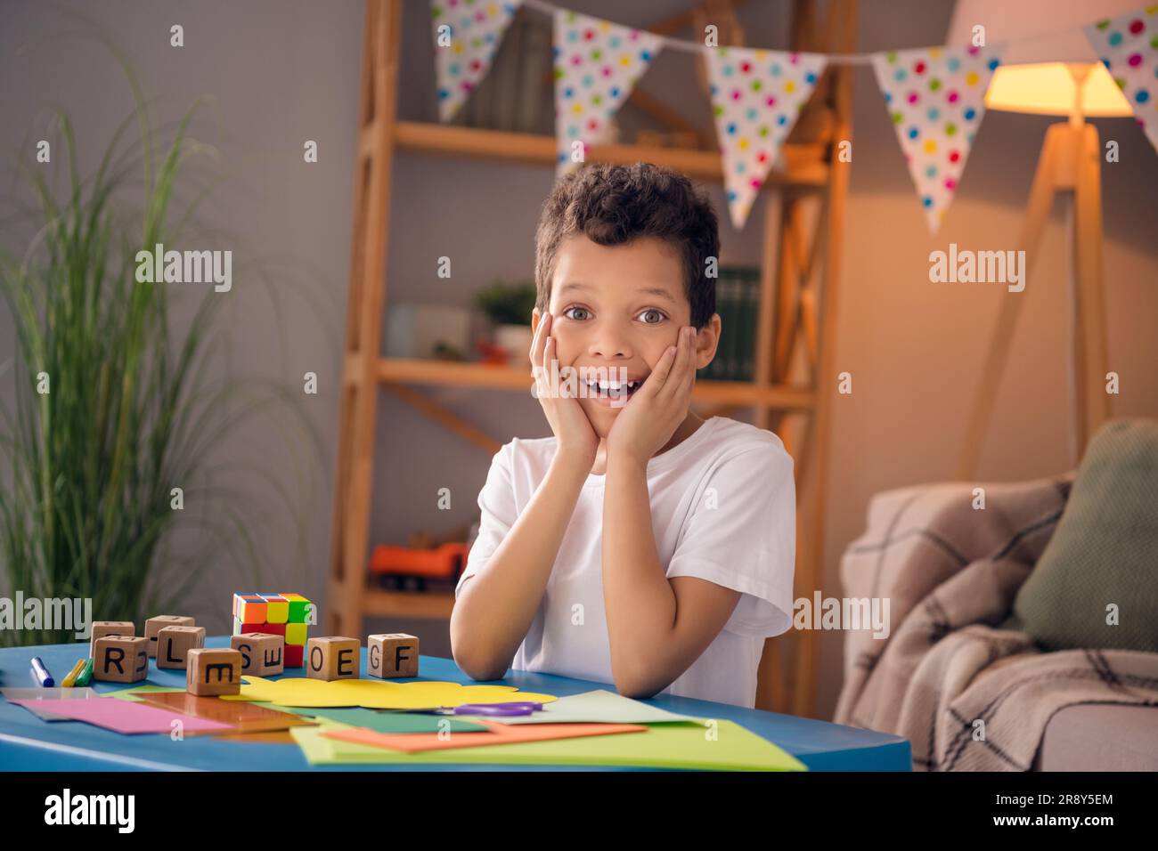 Photo of surprised cute boy playing table in nursery room impressed ...
