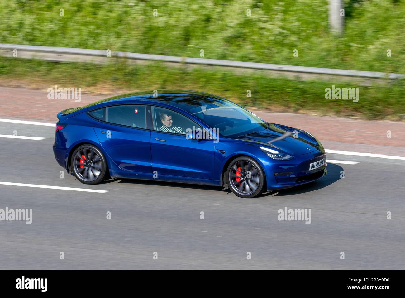 2022 Blue Tesla Model 3 Long Range AWD; travelling at speed on the M6 ...