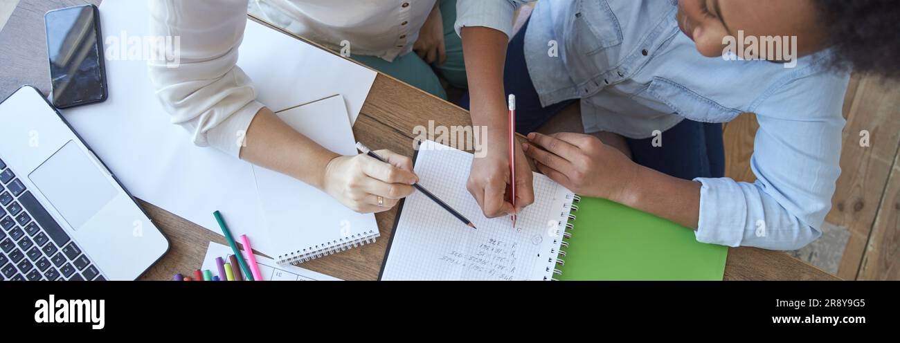 Top view of mixed race teen girl doing math task, school homework ...