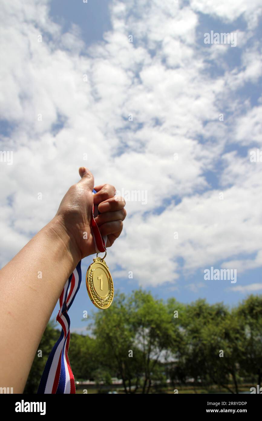Woman hand raised gold medal hi-res stock photography and images - Alamy