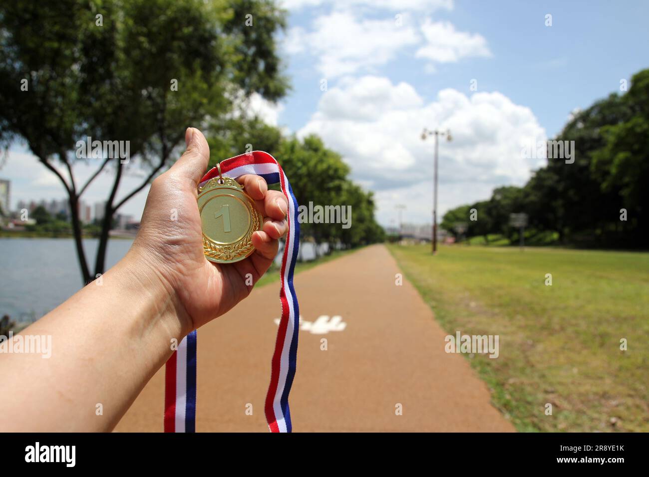 Blurred of woman hands raised and holding gold medals with Thai ribbon ...