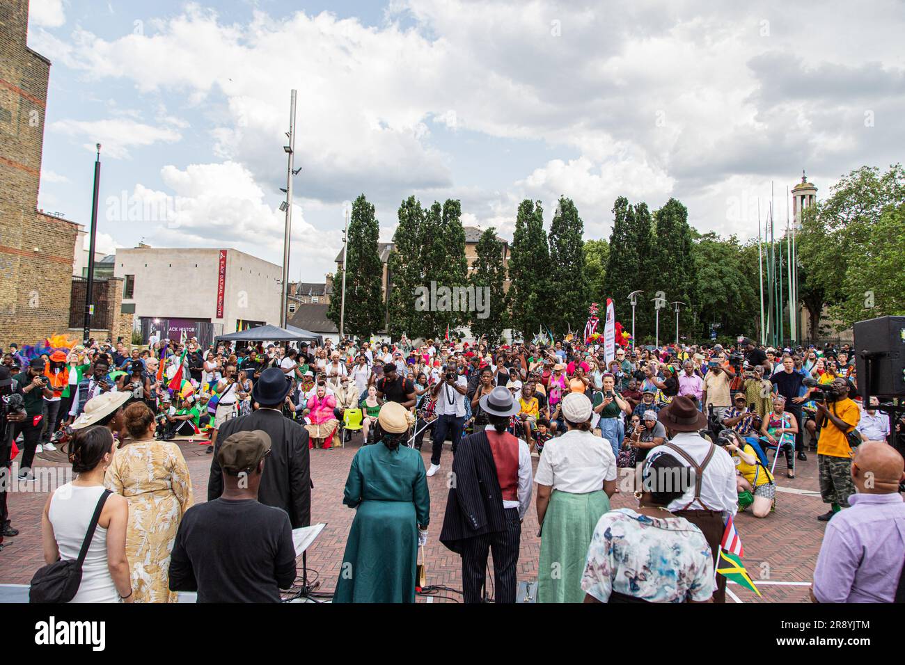 London, UK. 22nd June, 2023. People listen to performers in Windrush ...