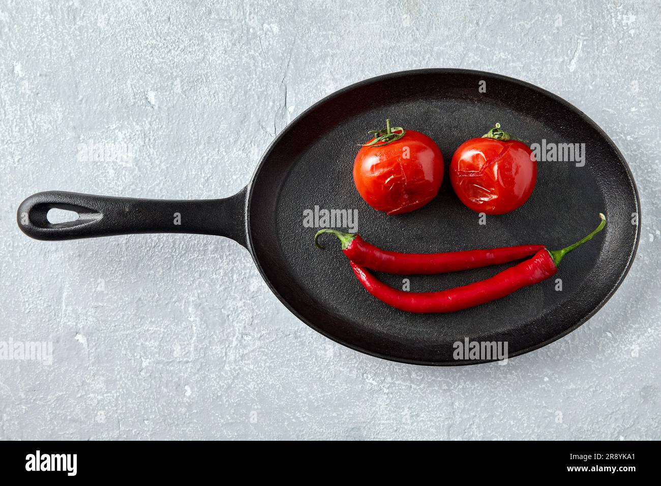 grilled baked tomatoes and red hot peppers laid out in the shape of a ...