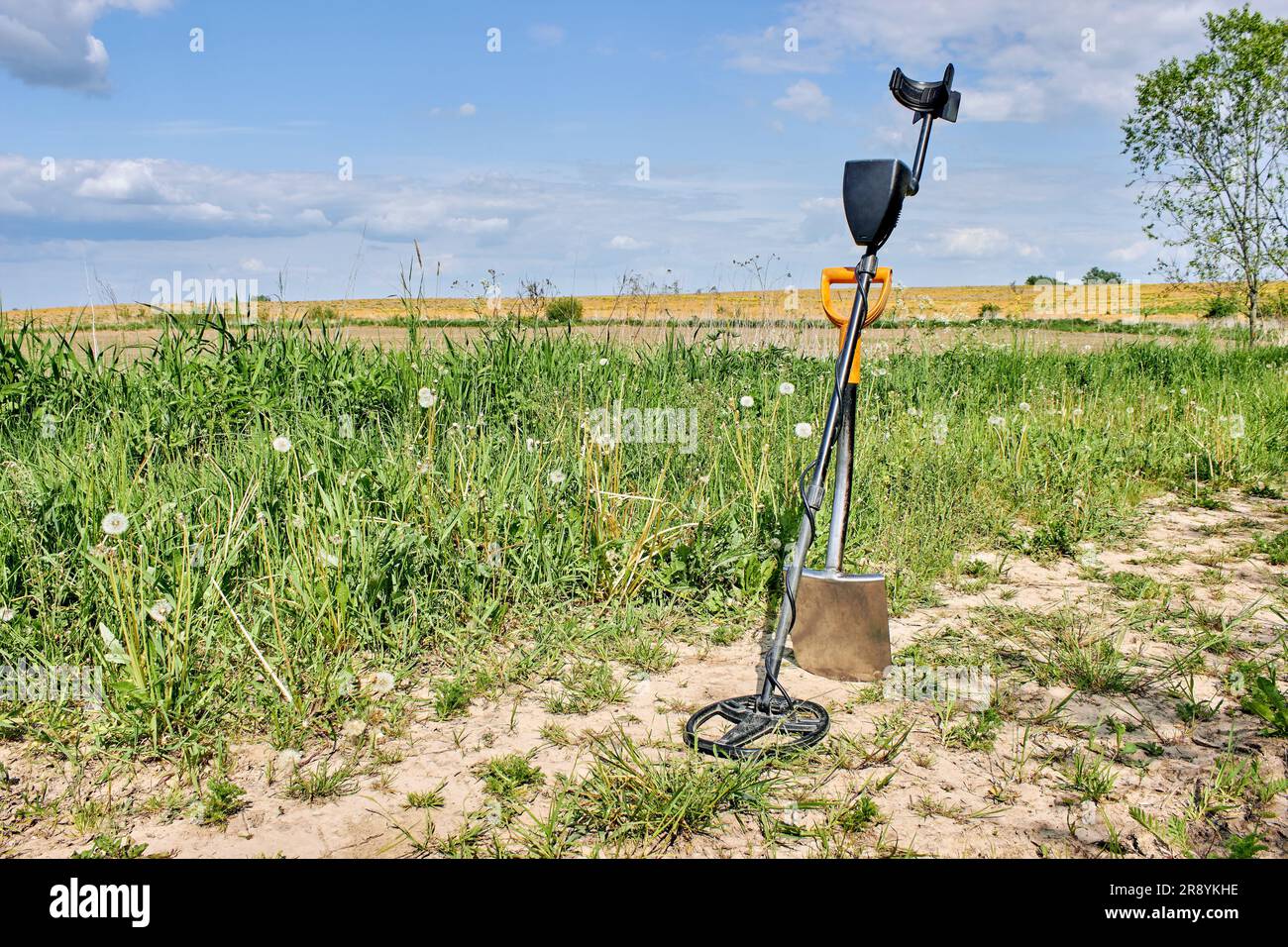 crossed metal detector and shovel on country road in field. tools for ...