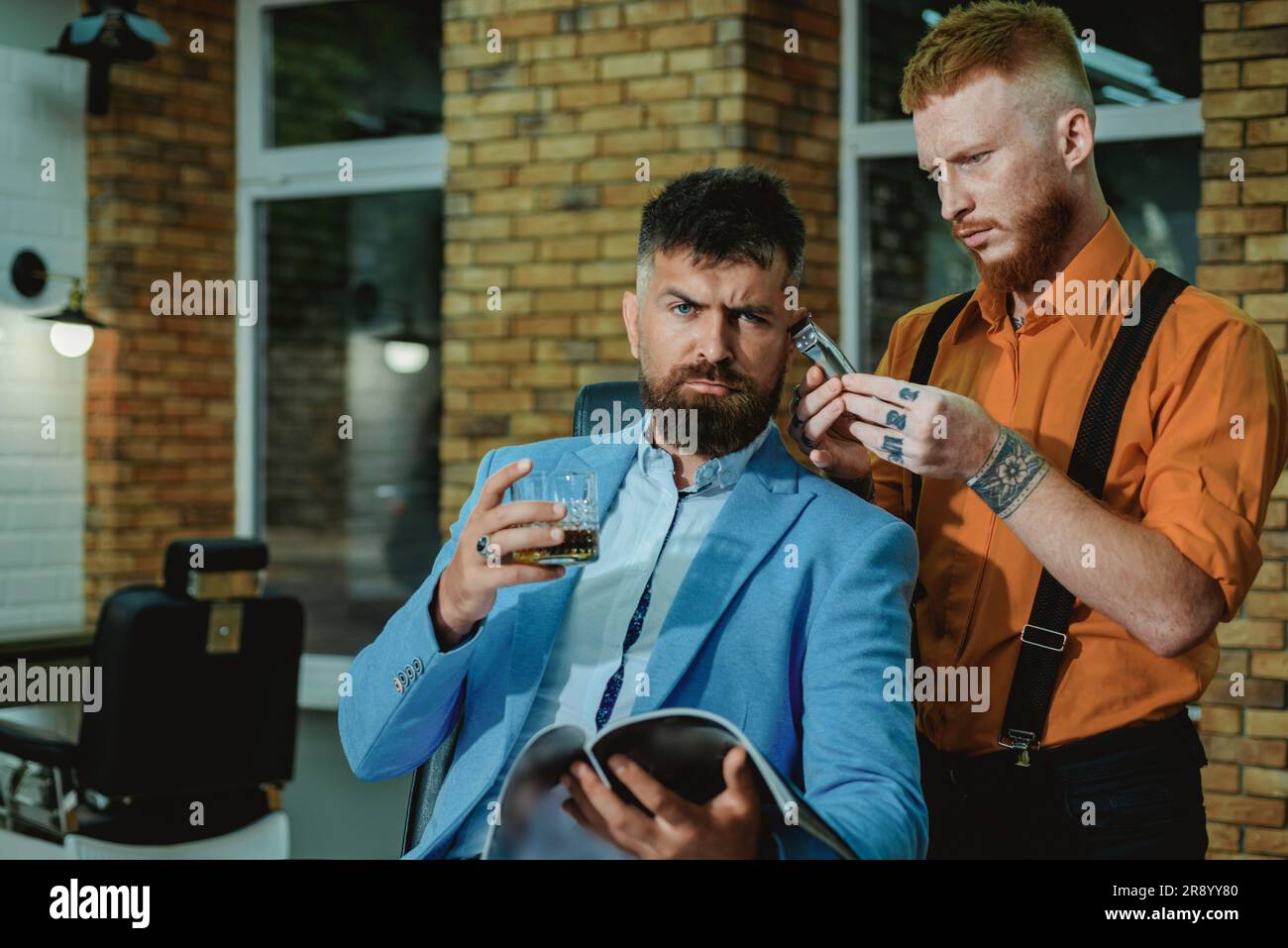 Barber shaving a bearded man in a barber shop. Hair salon and barber ...