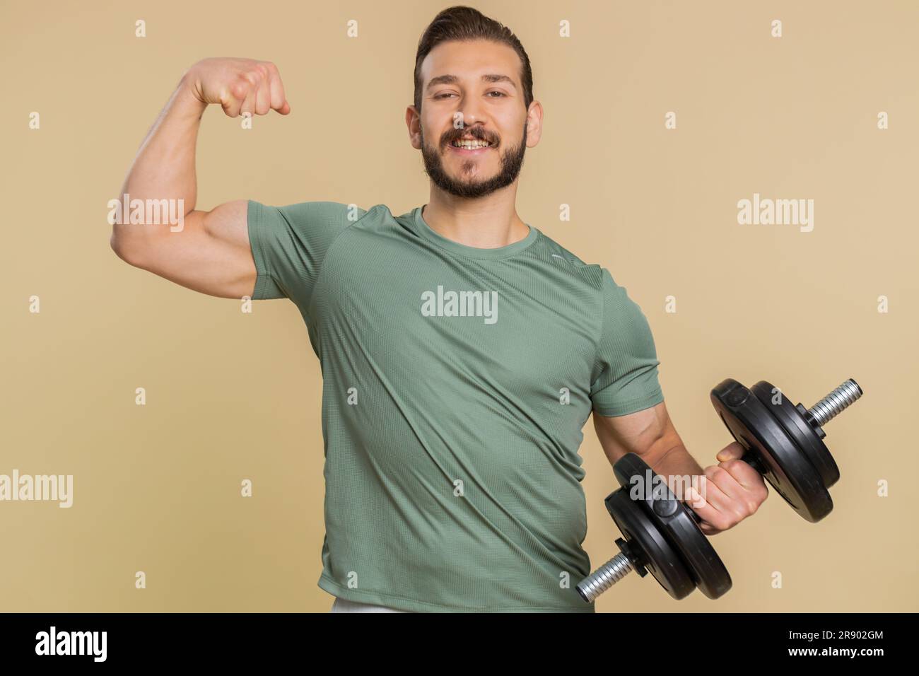 I am strong. Athlete sportive man showing biceps and looking confident ...