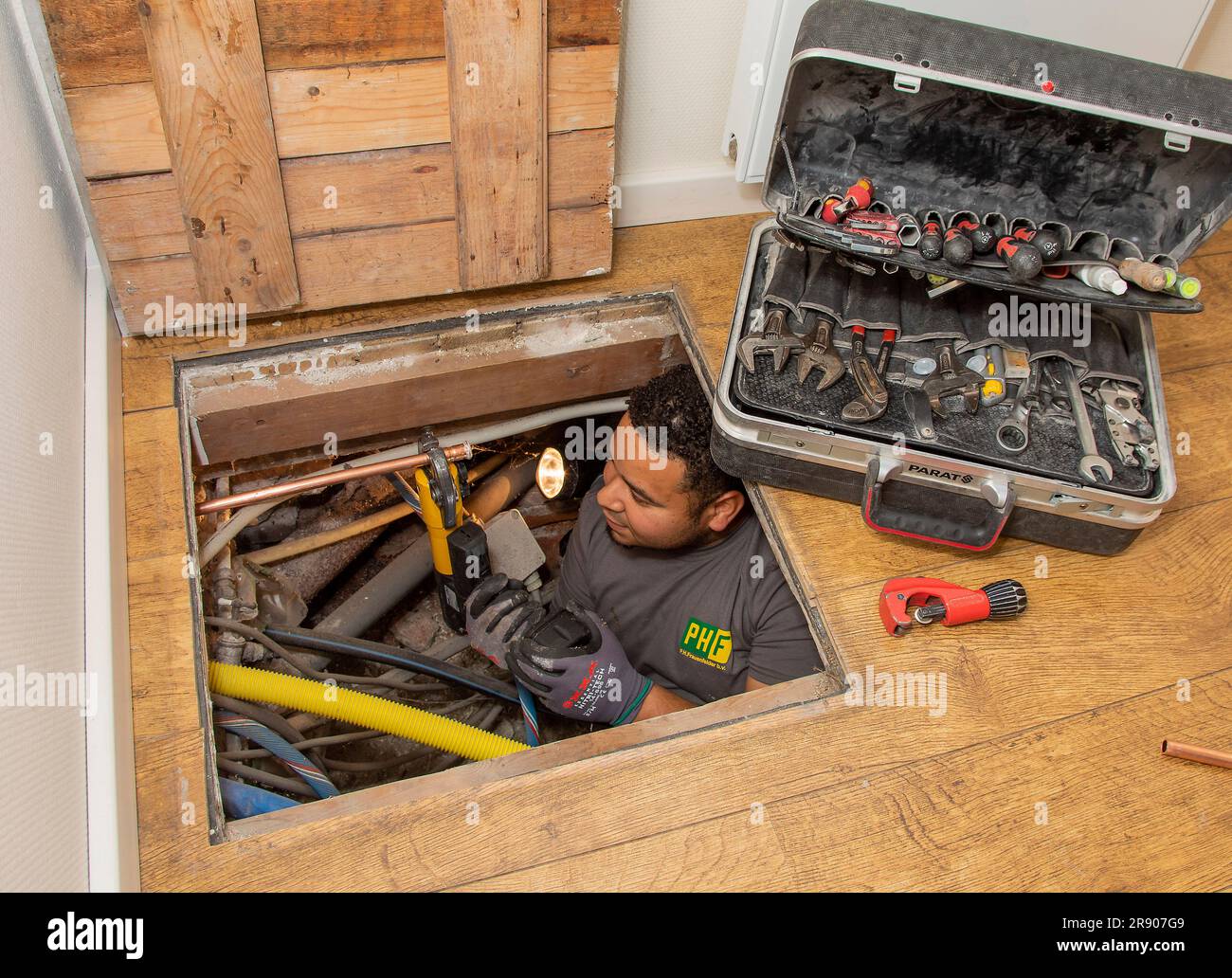 Netherlands, The Hague; plumber is repairing part of copper piping ...