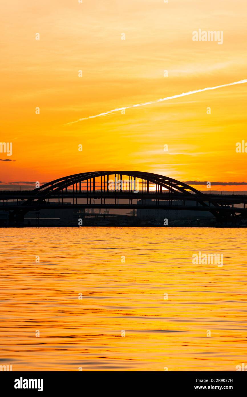 A vivid orange dawn sky and sunrise behind the silhouette of the double ...