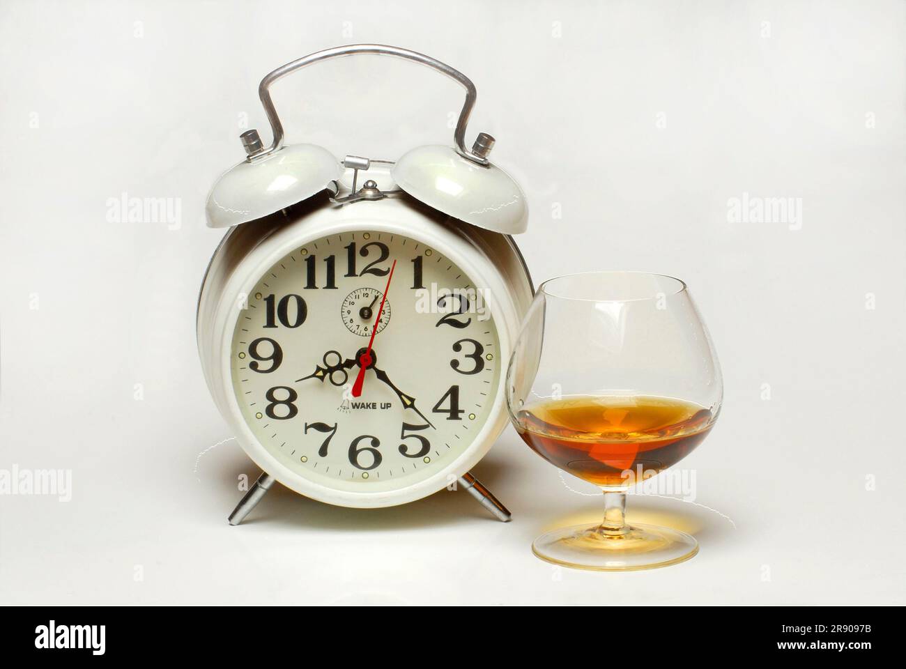 Alarm clock and glass of cognac, time, time, alcohol problem Stock ...