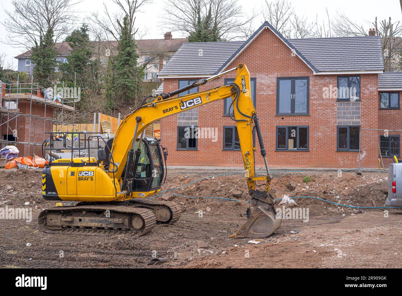 Large jcb digger in front of new-build homes - UK building industry ...