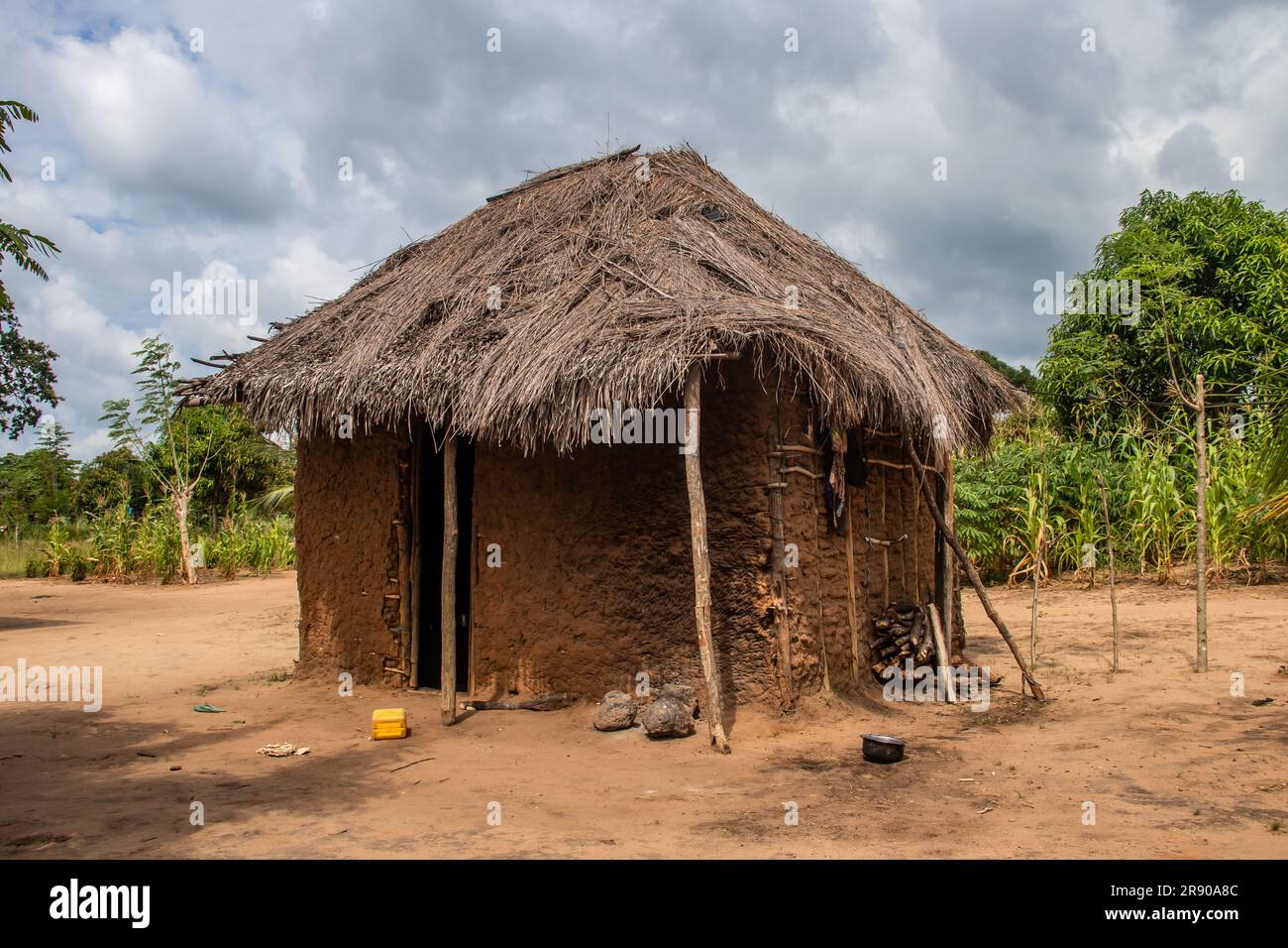 Typical rural mud-house in remote village in Africa with thatched roof ...