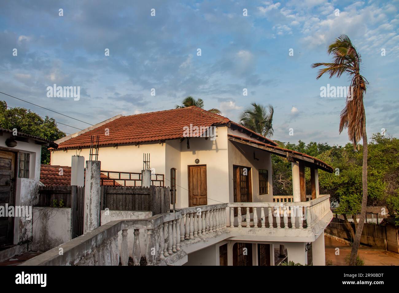 Old white house with big balcony connecting two buildings, at the beach ...