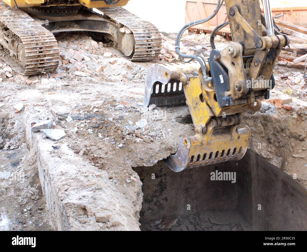 An excavator tears off the ceiling of a cellar during the demolition of ...
