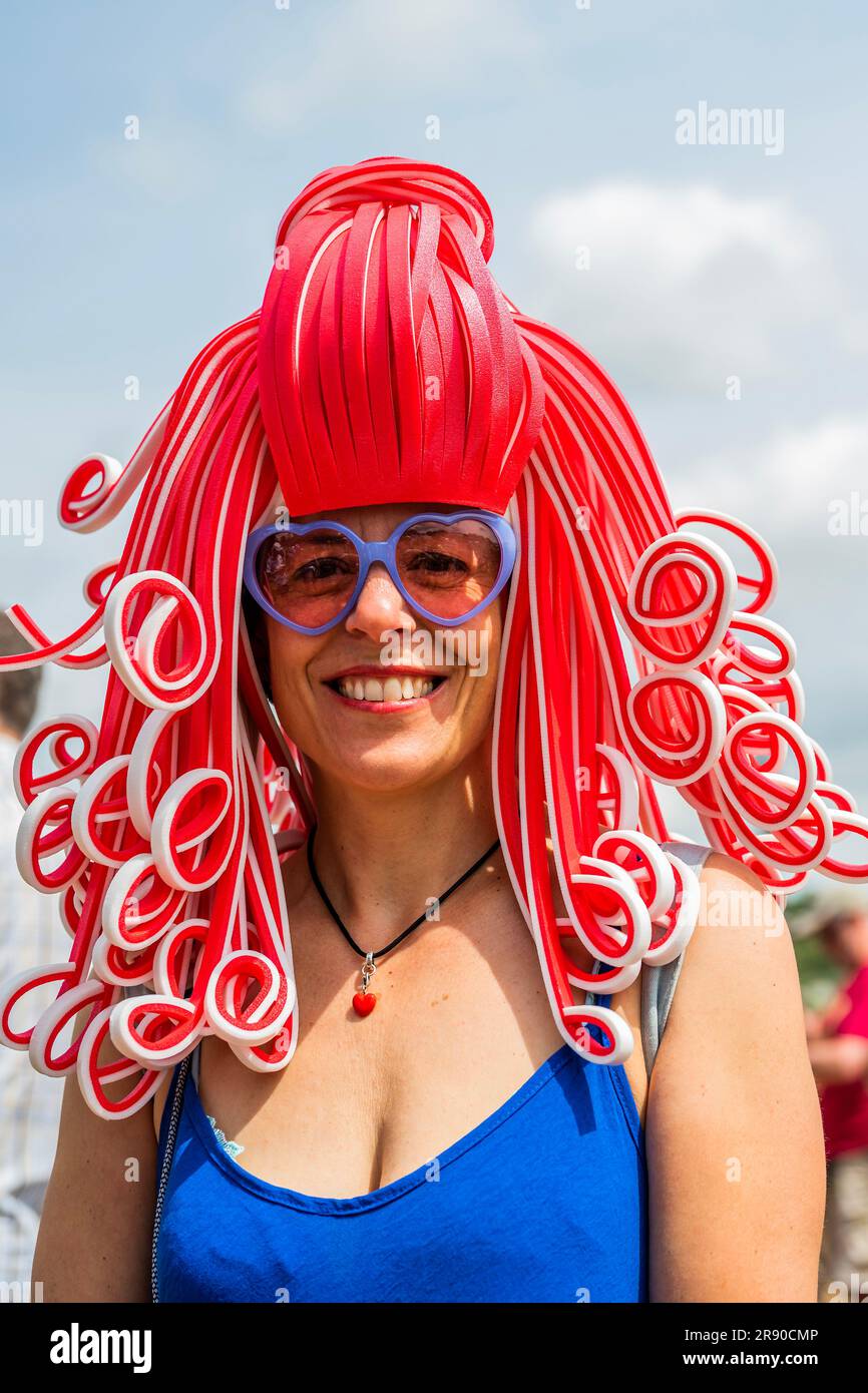 Glastonbury, UK. 23rd June, 2023. A woman in a stylised foam wig ...