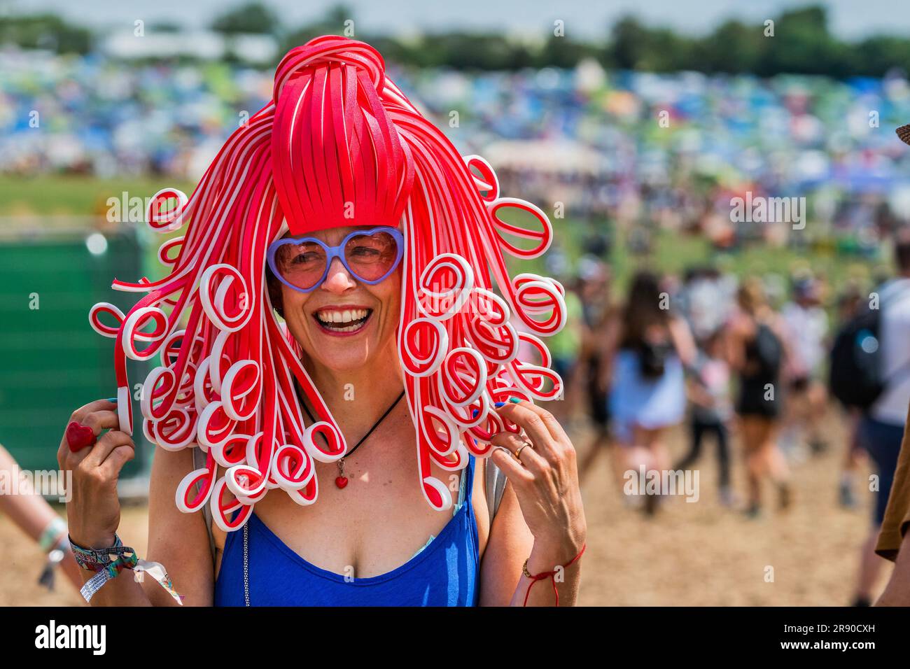 Glastonbury, UK. 23rd June, 2023. A woman in a stylised foam wig ...