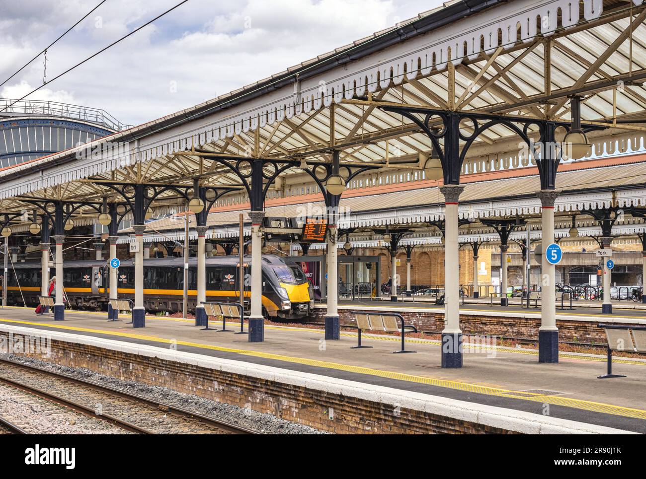 A train stands at a platform between two historic 19th Century canopies ...