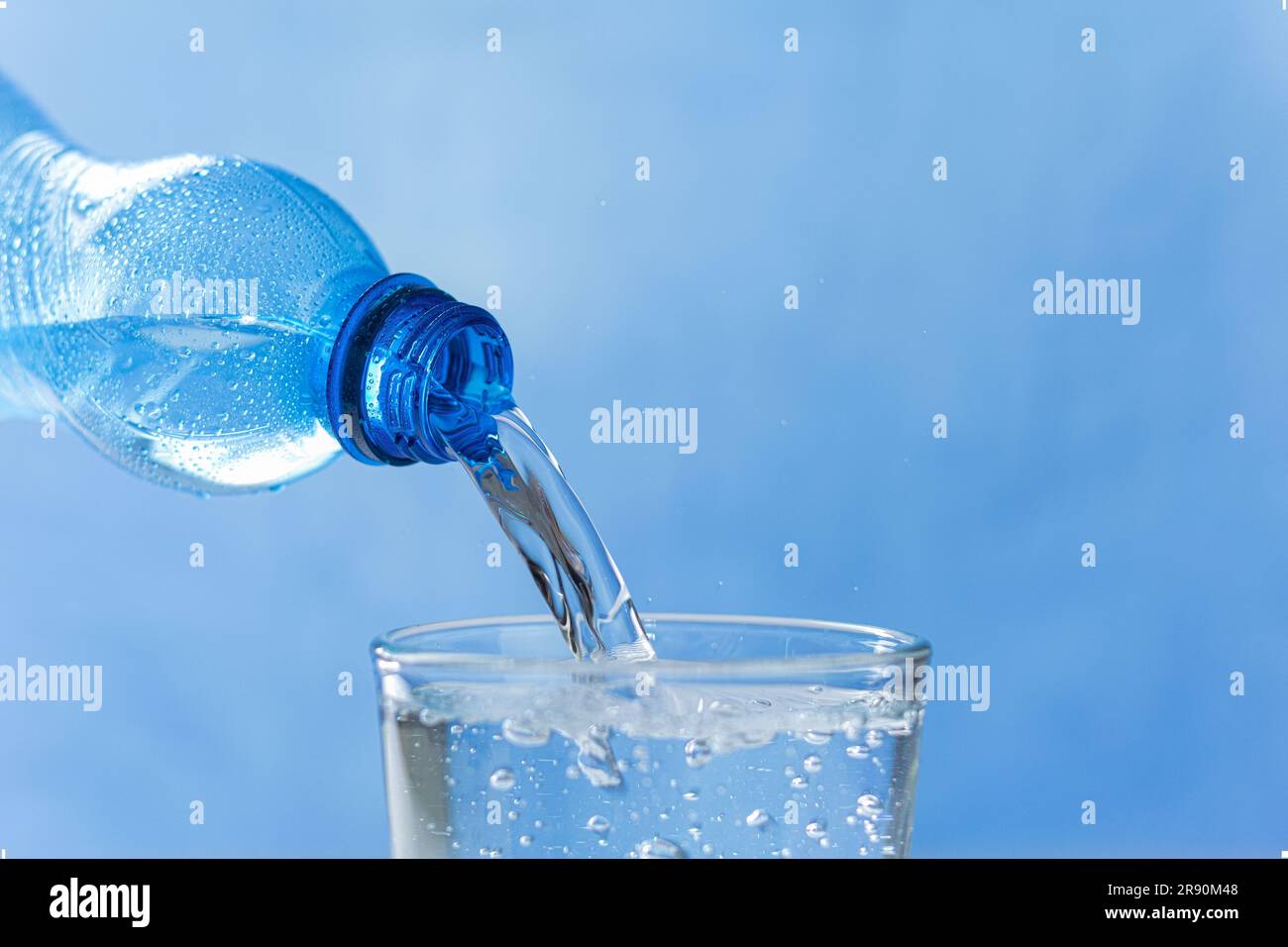 Fresh and cool water flows from the neck of the bottle. Water is poured ...