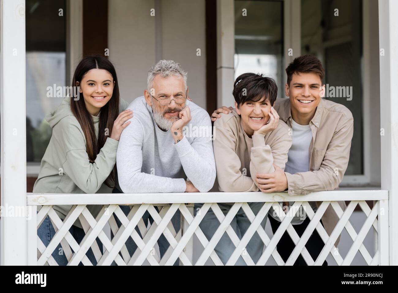 happy parents day, middle aged parents smiling next to teenage daughter ...