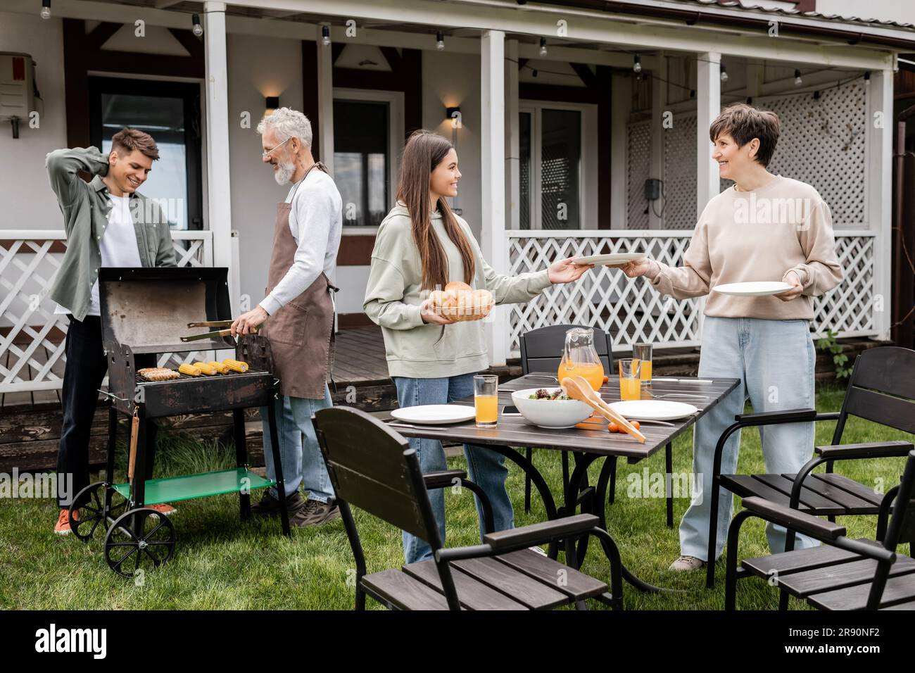 parents day, cheerful teenage girl helping mother serving the table ...