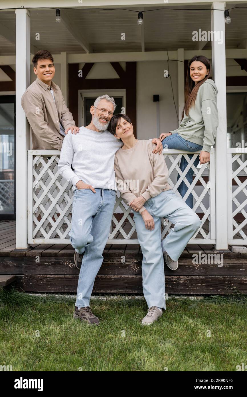 family photo, parents day, middle aged parents posing next to daughter ...