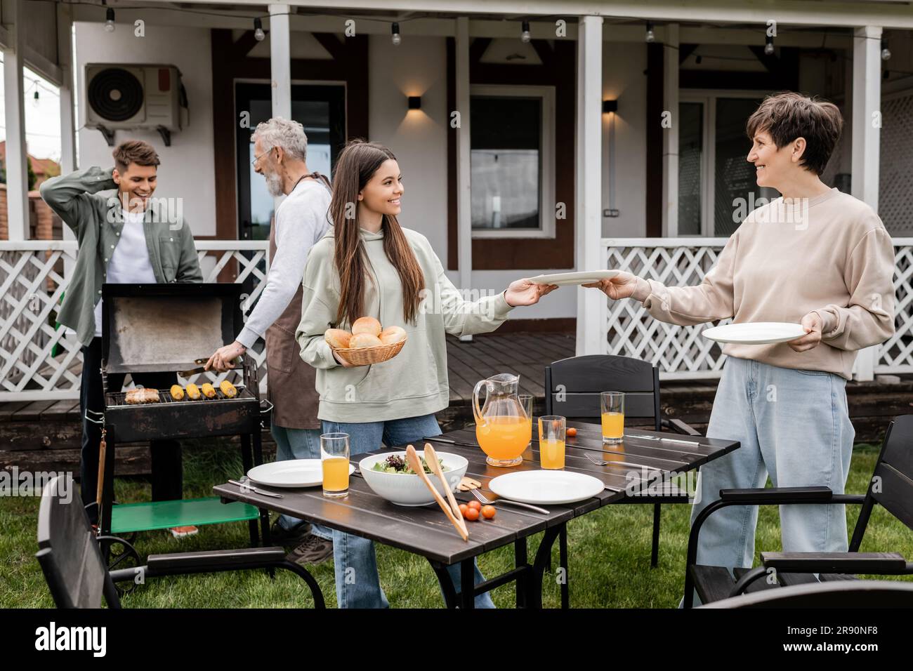 parents day, happy teenage girl helping mother serving the table ...