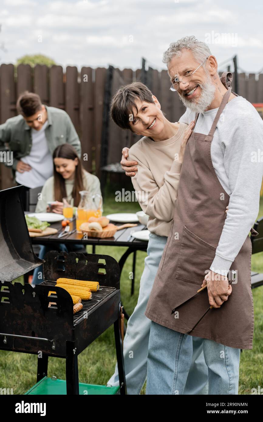 parents day, middle aged couple smiling during bbq party, bearded man ...