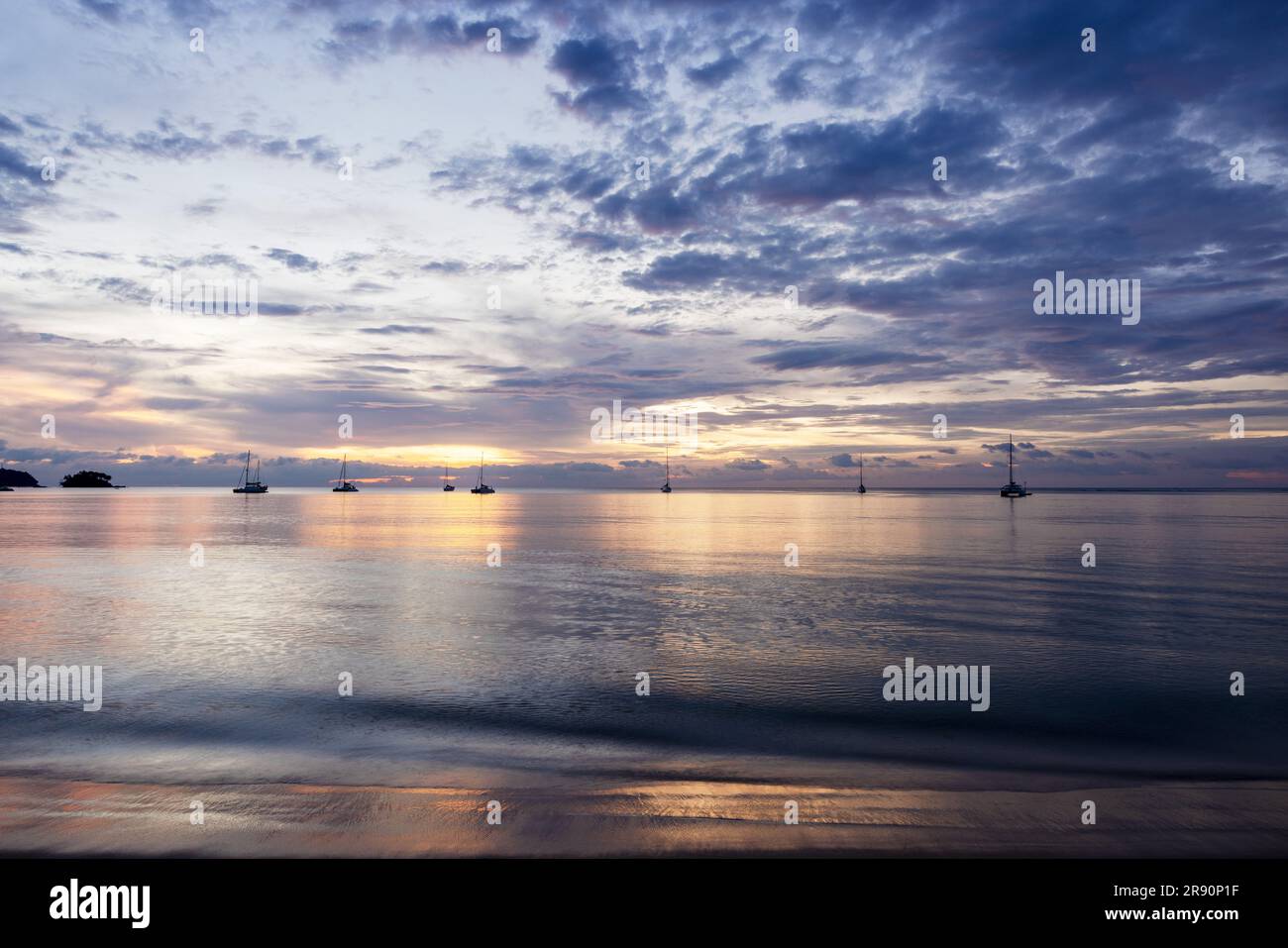 Magical sun setting on the beach of Naiyang on the island of Phuket in ...