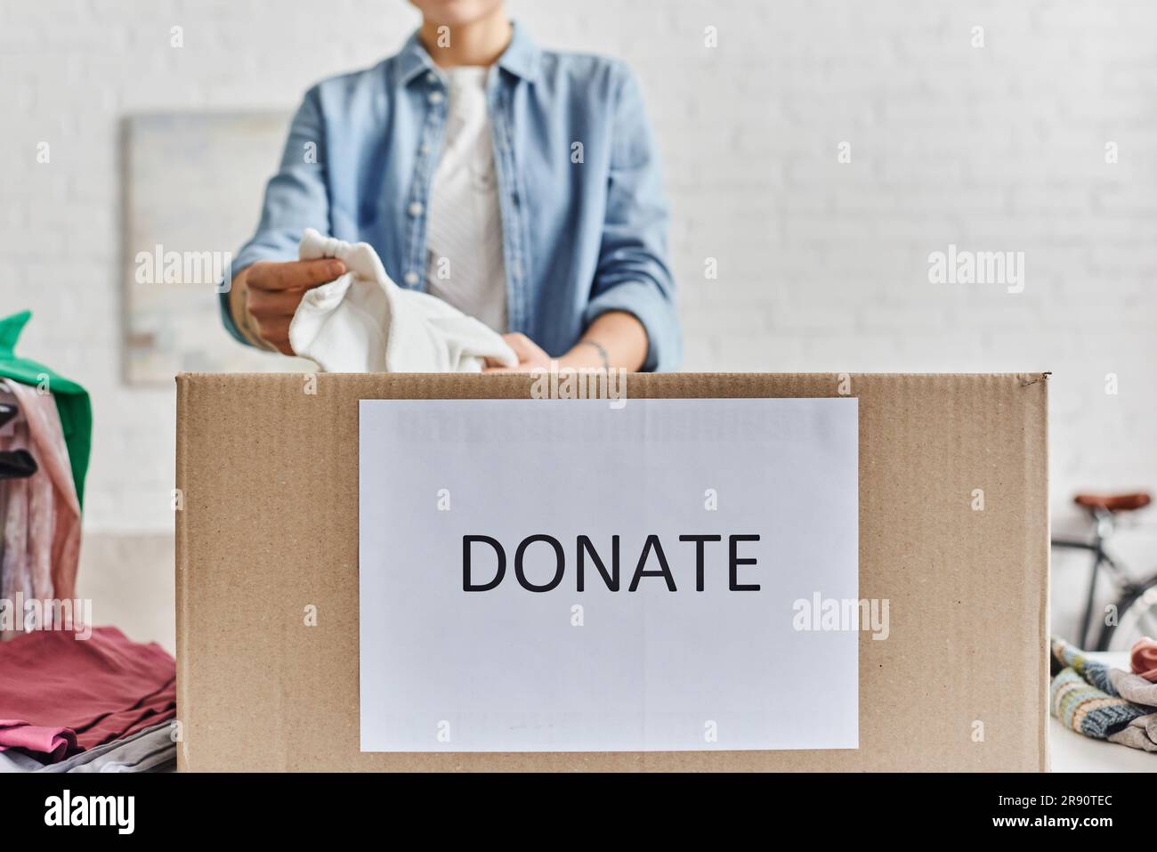 social good initiatives, partial view of young woman packing clothing ...
